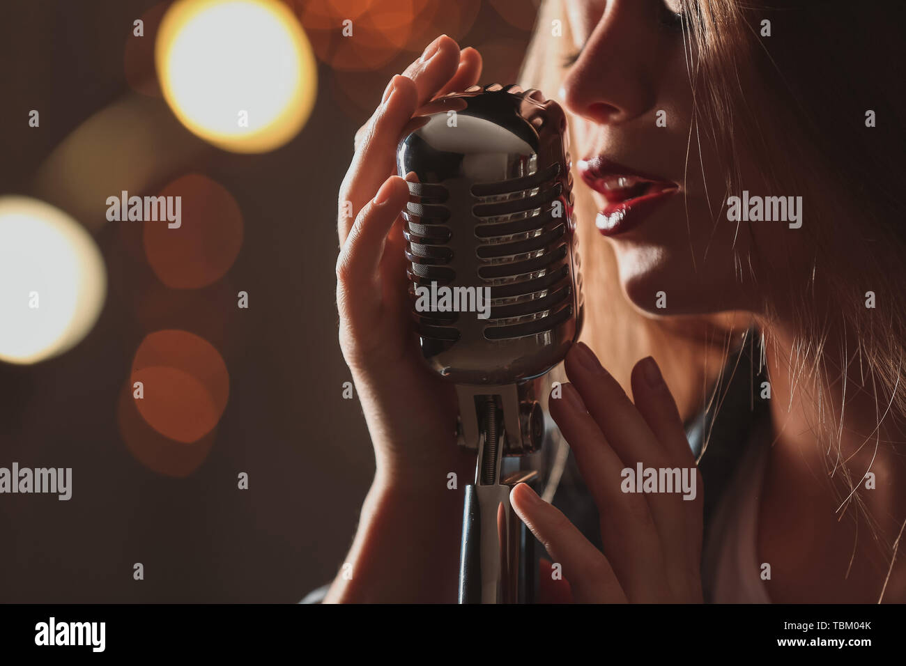 Beautiful female singer with microphone on stage, closeup Stock Photo ...
