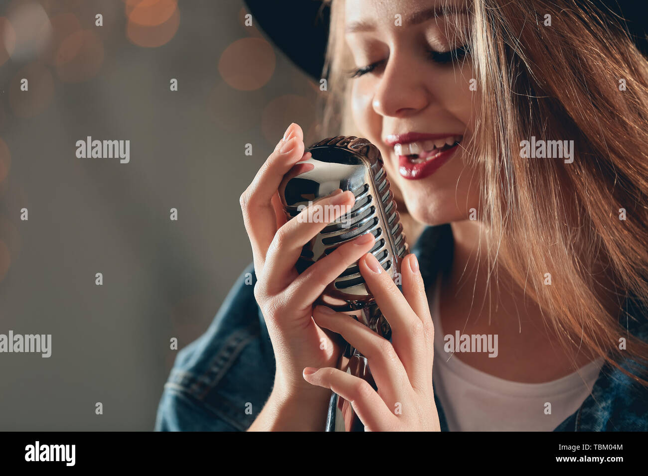 Beautiful female singer with microphone on stage Stock Photo - Alamy