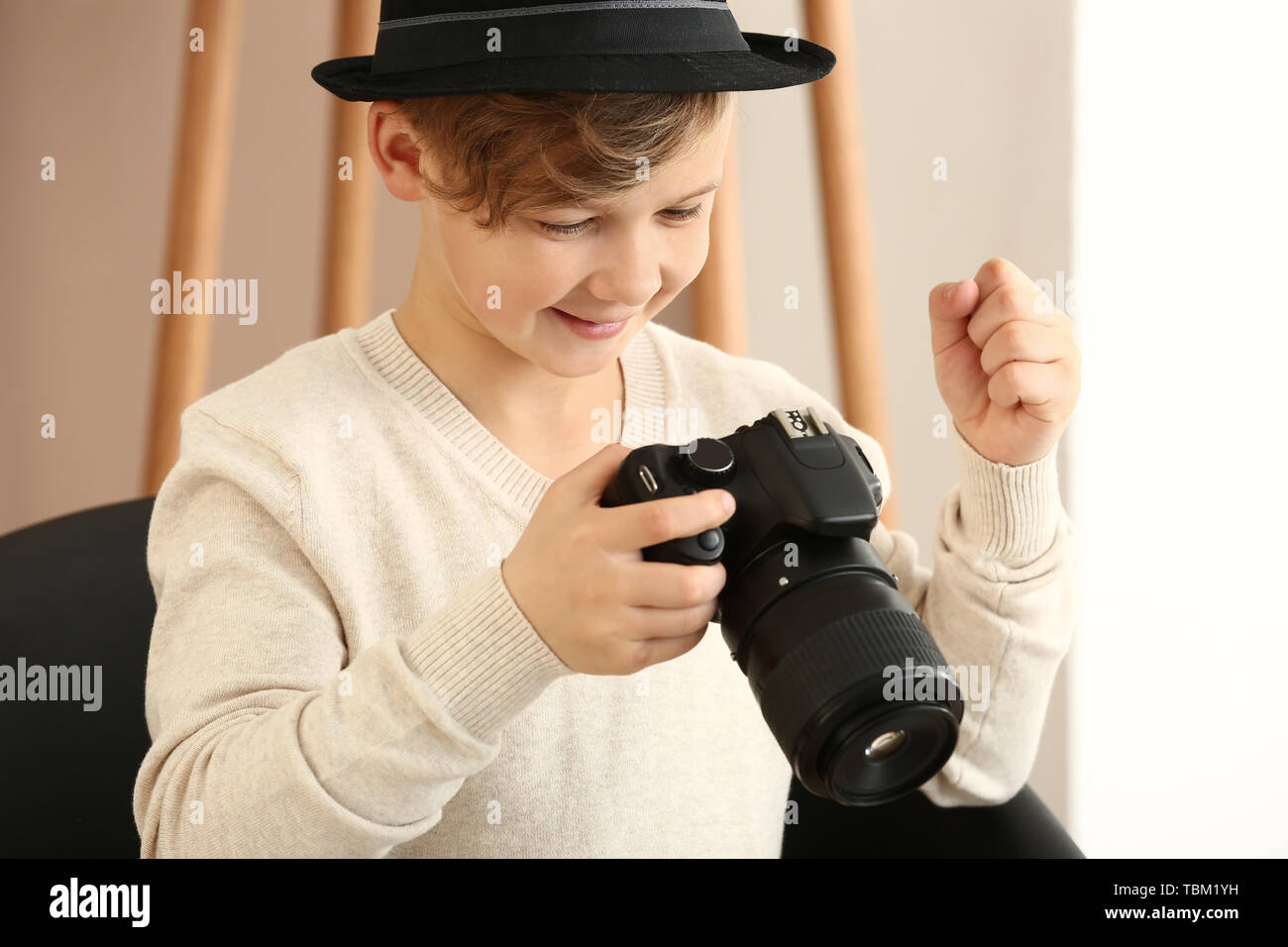 Cute little photographer with professional camera at home Stock Photo ...