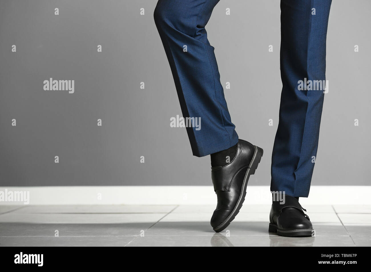 Young man in elegant shoes near color wall Stock Photo - Alamy