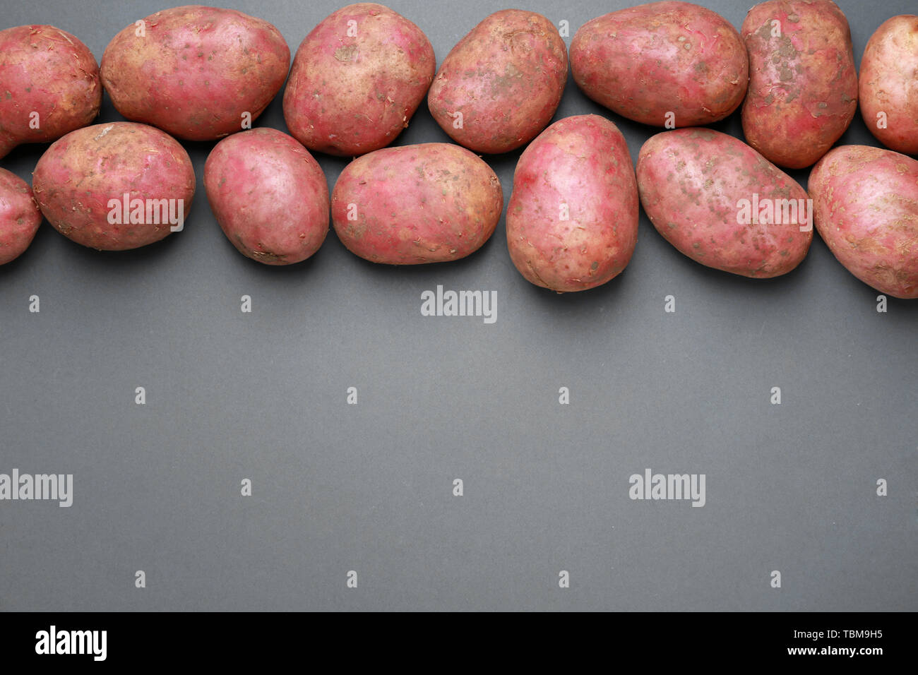Raw potato on grey background Stock Photo - Alamy