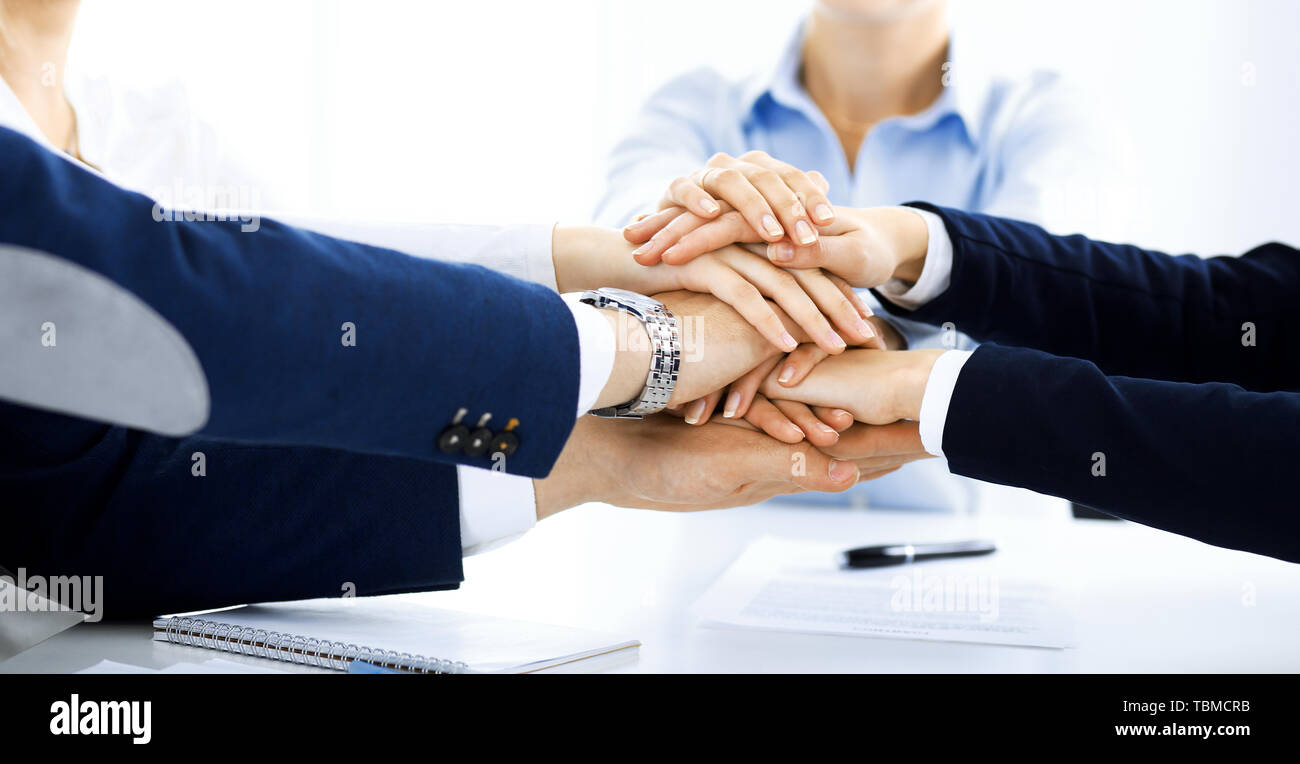 Business team showing unity with their hands together. Group of people joining hands and ...