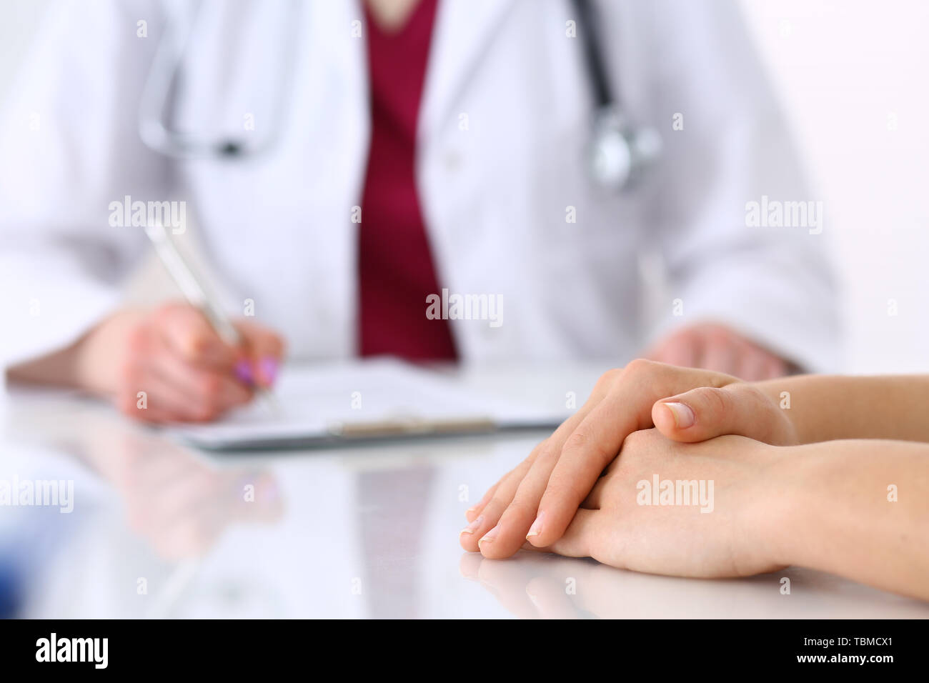 Unknown doctor woman consulting patient while filling up an application ...