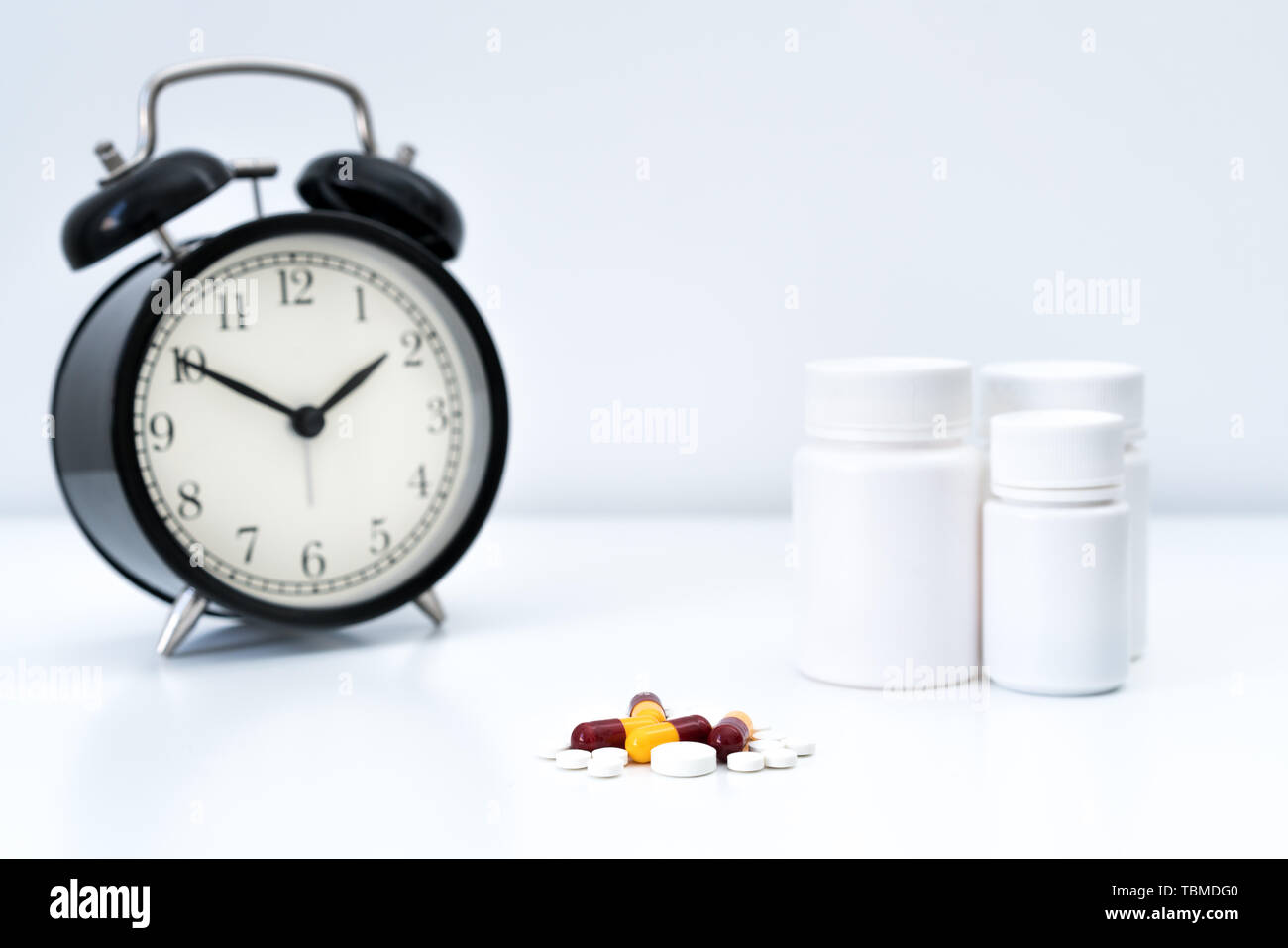 Alarm clock pills and capsules Stock Photo - Alamy