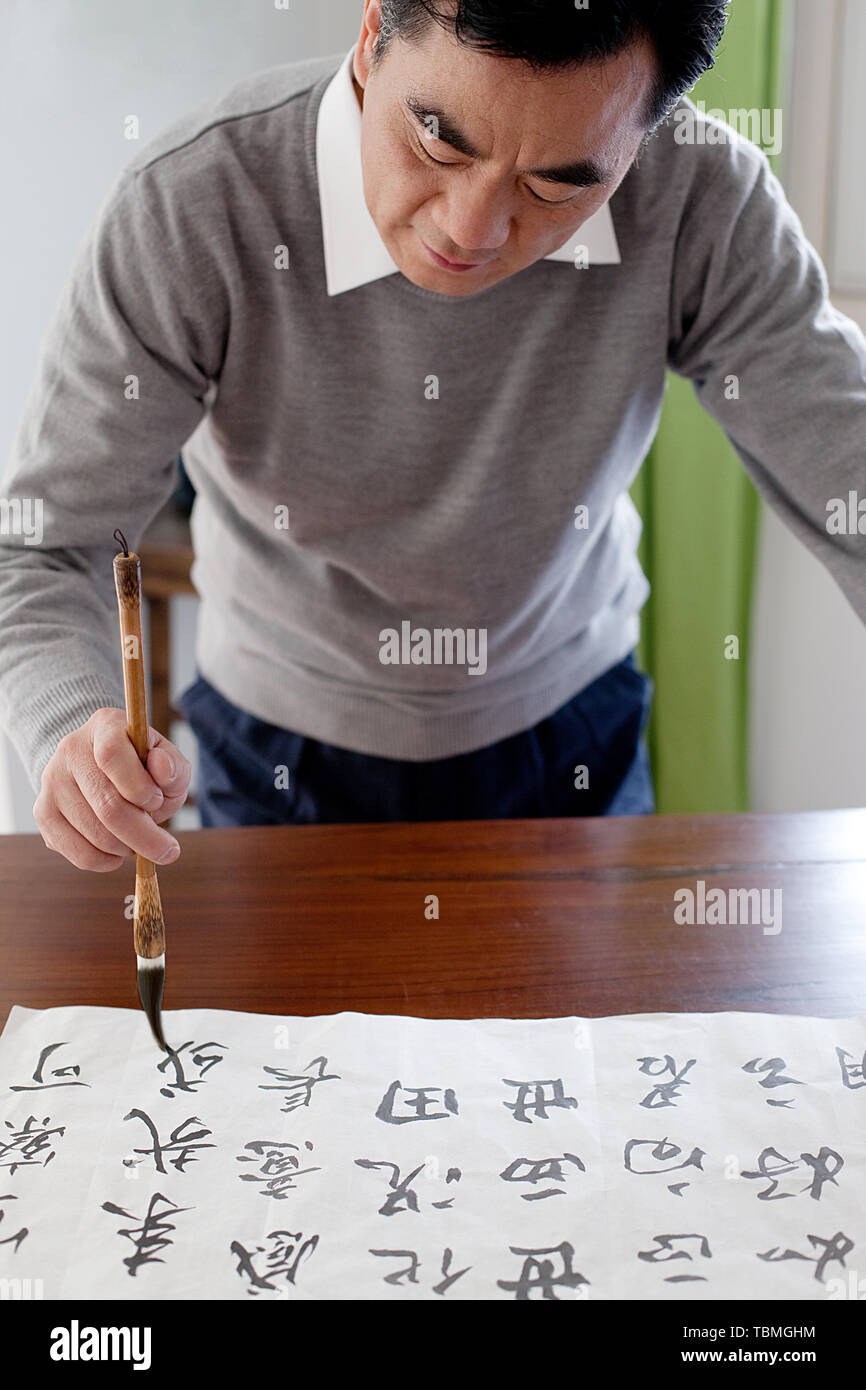 An elderly man practicing calligraphy Stock Photo - Alamy