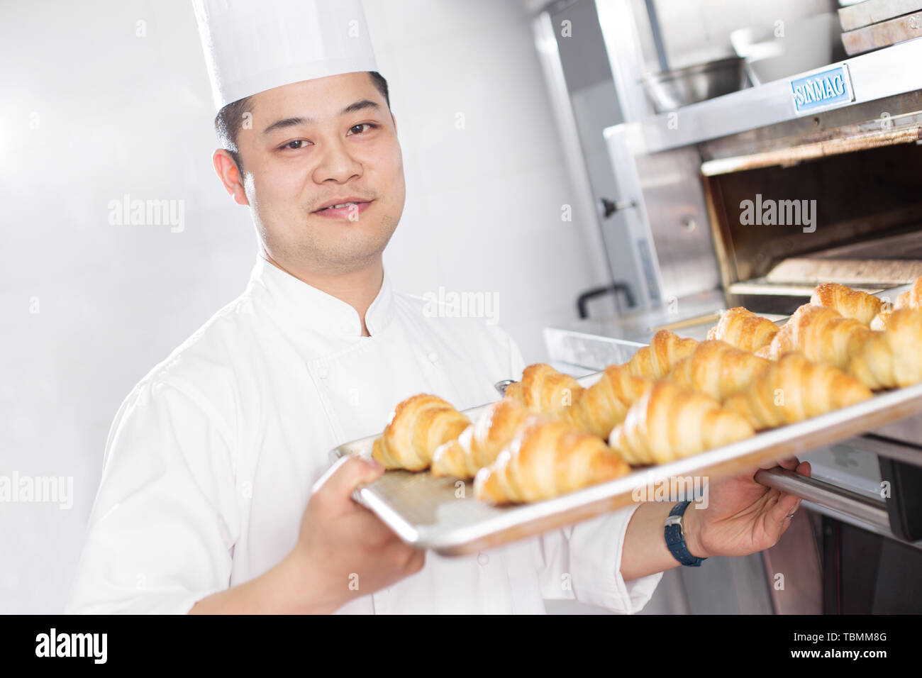 young chinese man chelf making bread in kitchen Stock Photo - Alamy
