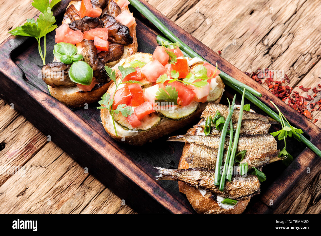Variety of small sandwiches.Bruschetta on wooden cutting board ...