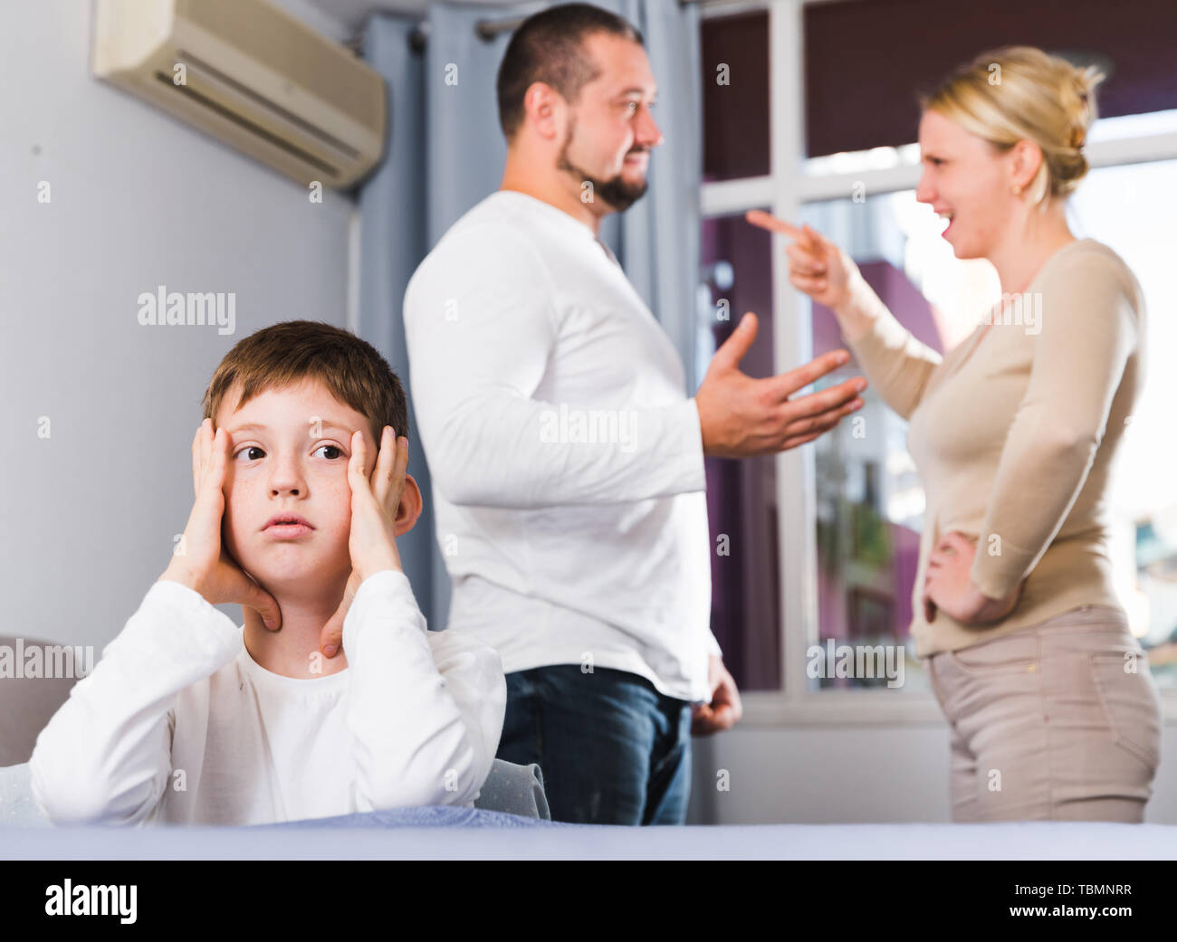 Upset tired son suffering from mom and dad arguing at home Stock Photo ...