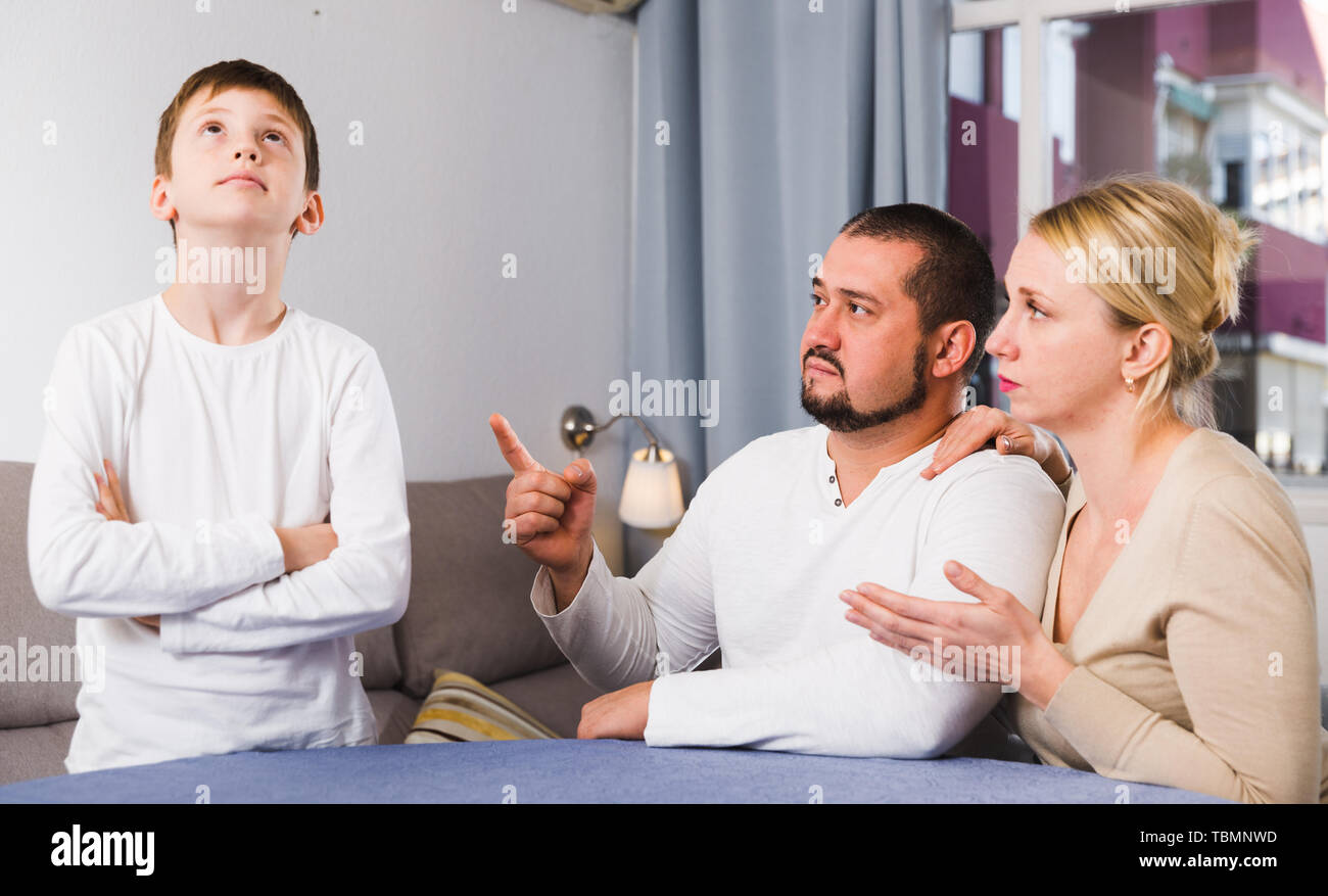 Serious young parents scolding son at home Stock Photo - Alamy