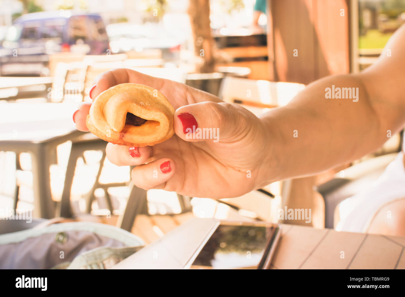 hand of a woman holding a Spanish bollo preñado. Traditional bread with ...