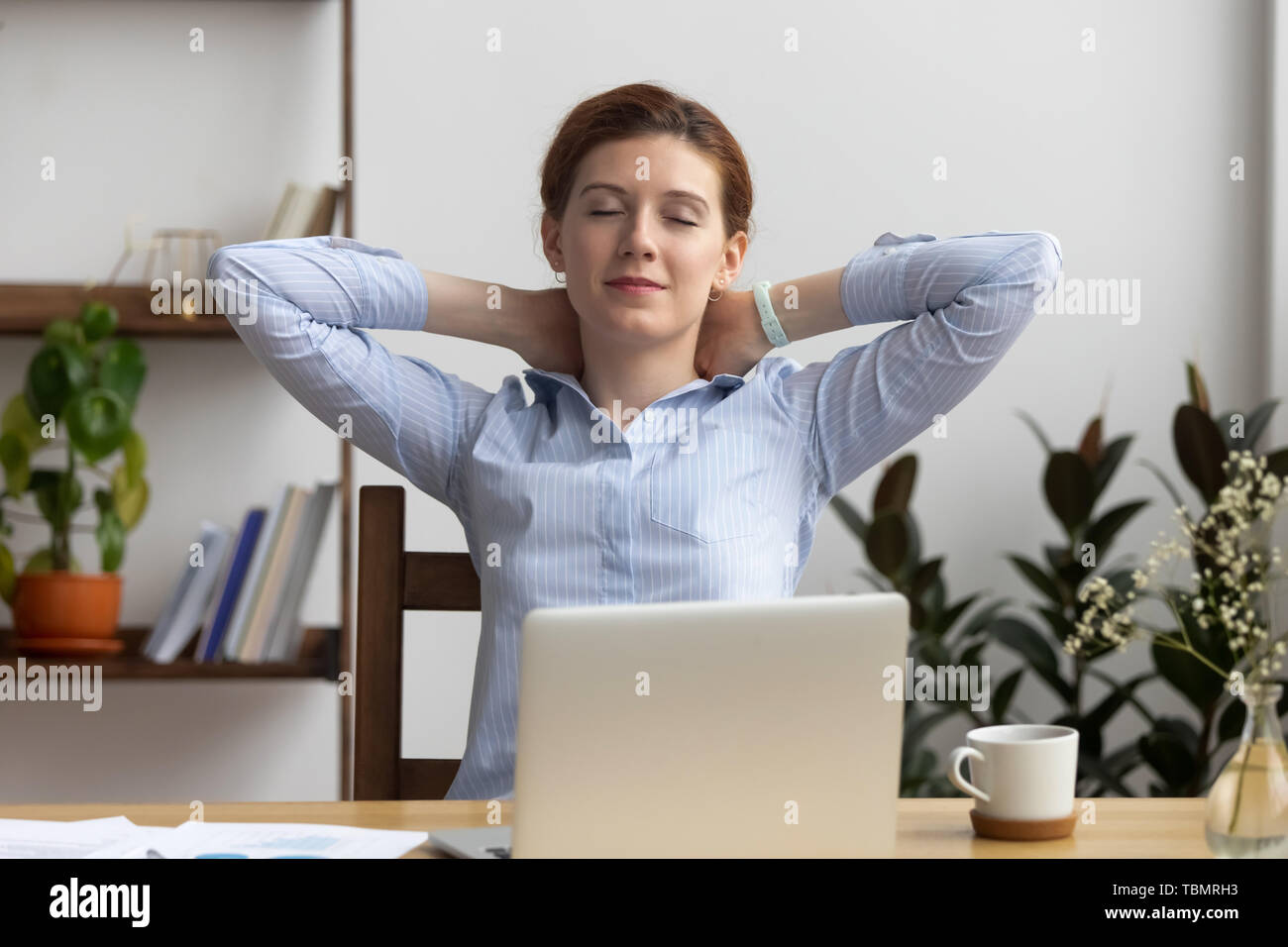 Young businesswoman visualizing dreams with eyes closed in office Stock ...