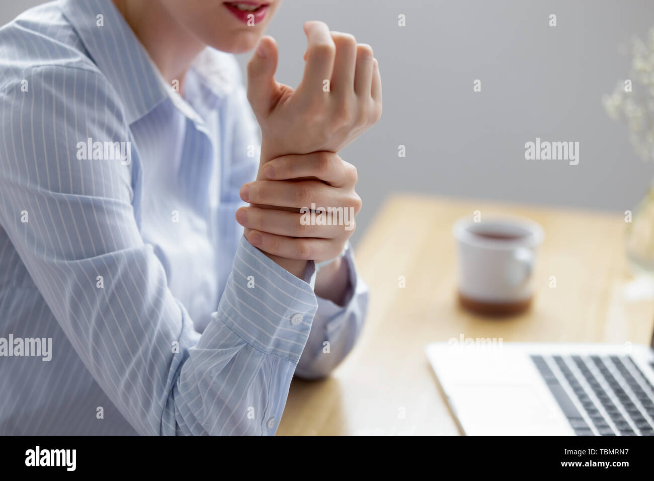 Close up businesswoman holding hand feeling wrist pain from laptop ...