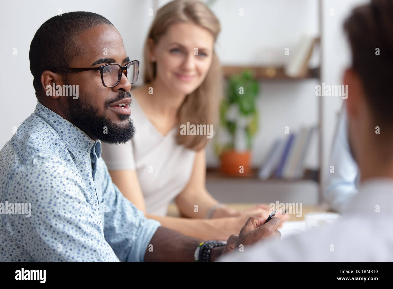 Male african-american talking to coworkers timeout in office Stock ...