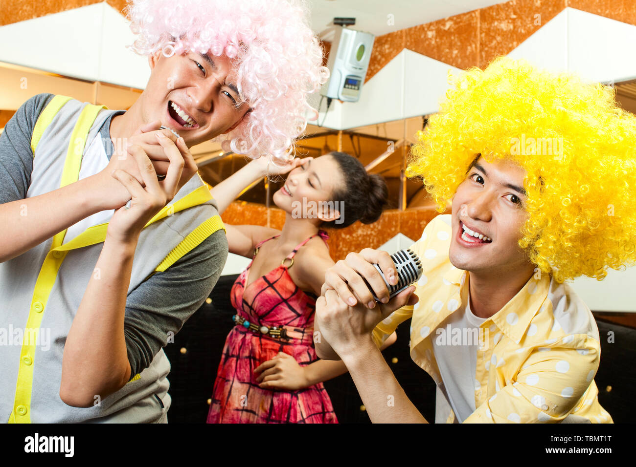 Three friends sing at KTV party Stock Photo - Alamy