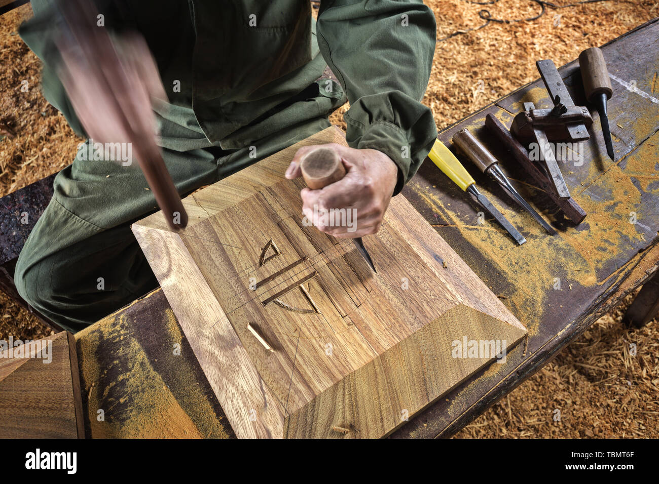 wood chisel carpenter tool hammer in hand working wooden background ...