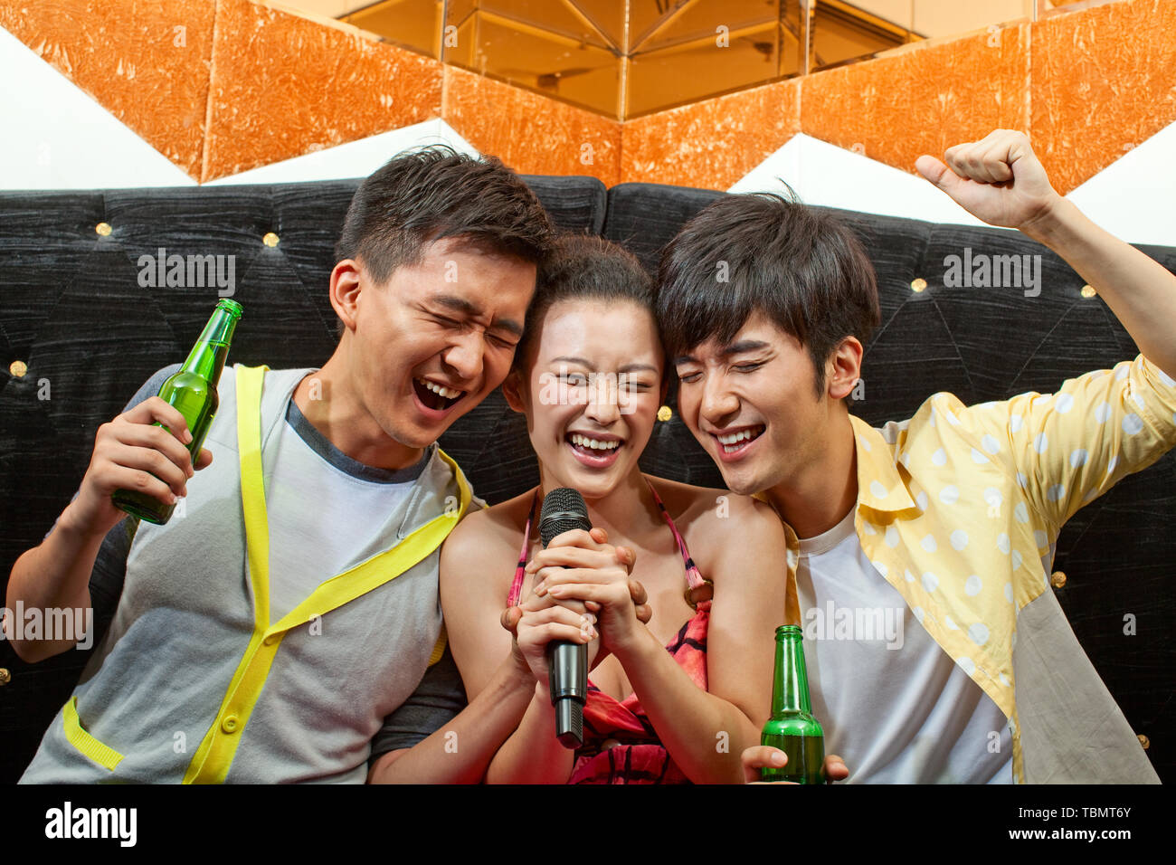 Three friends sing at KTV party Stock Photo - Alamy
