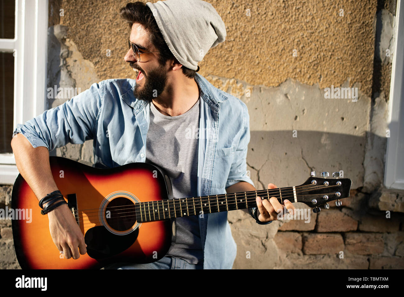 Young musician handsome man with guitar in city Stock Photo - Alamy