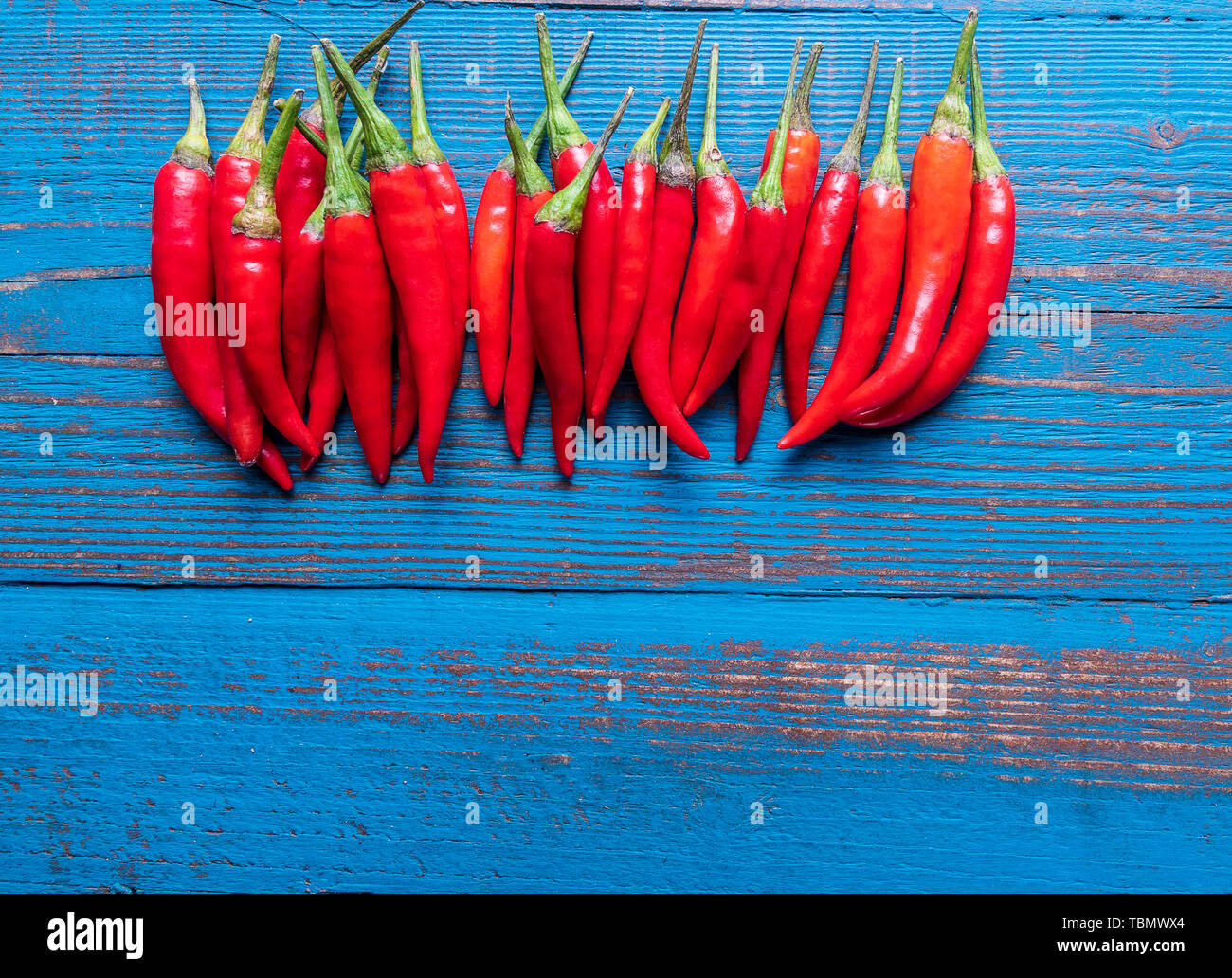 Top view Red ripe small chili peppers pattern over old wooden blue ...