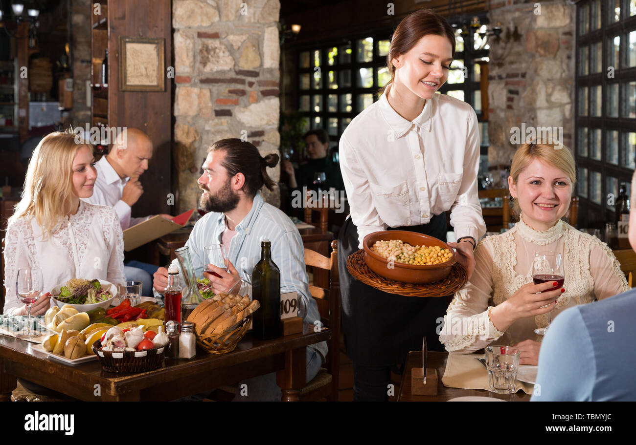 Young female waiter serving country restaurant guests Stock Photo - Alamy