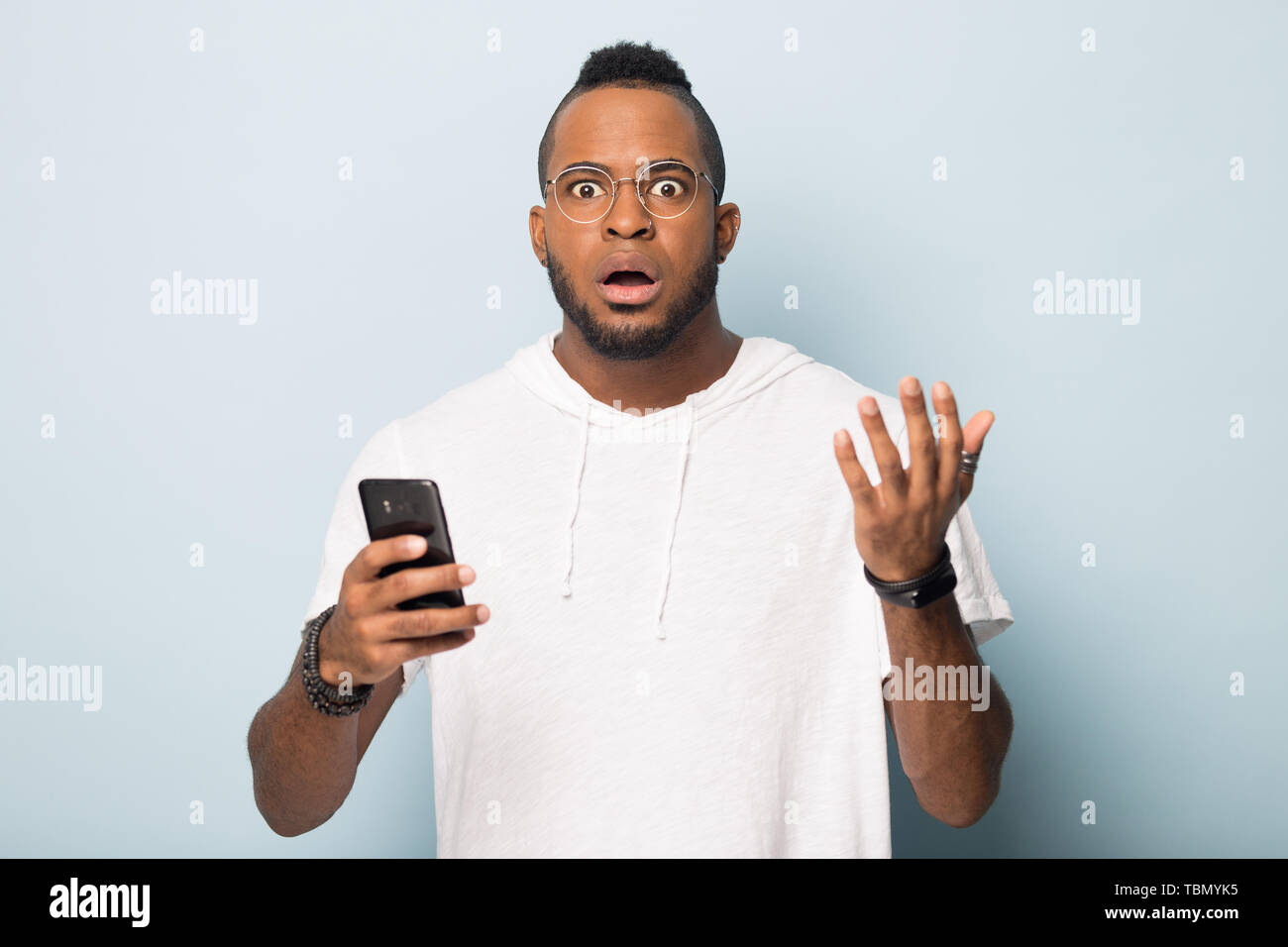 Surprised african American man get unexpected message on cellphone ...