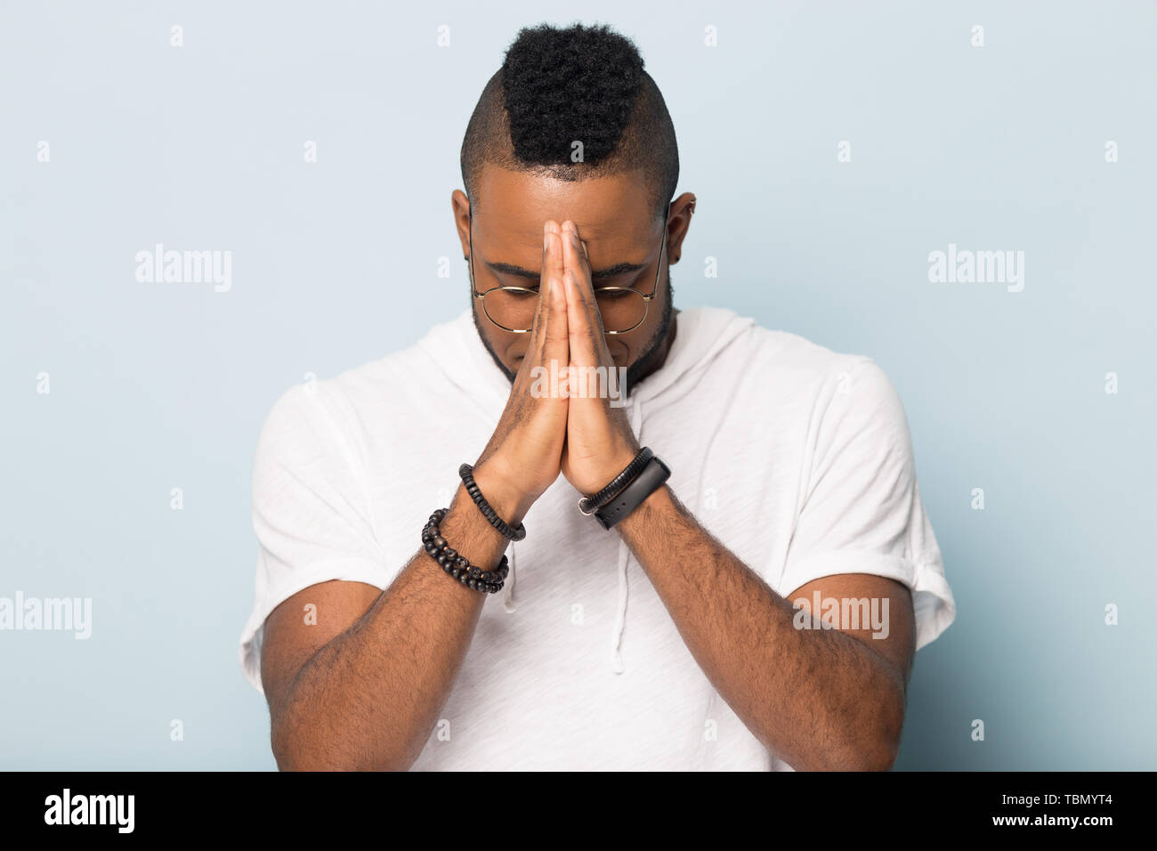 Hopeful black man hold hands in prayer hope for luck Stock Photo - Alamy