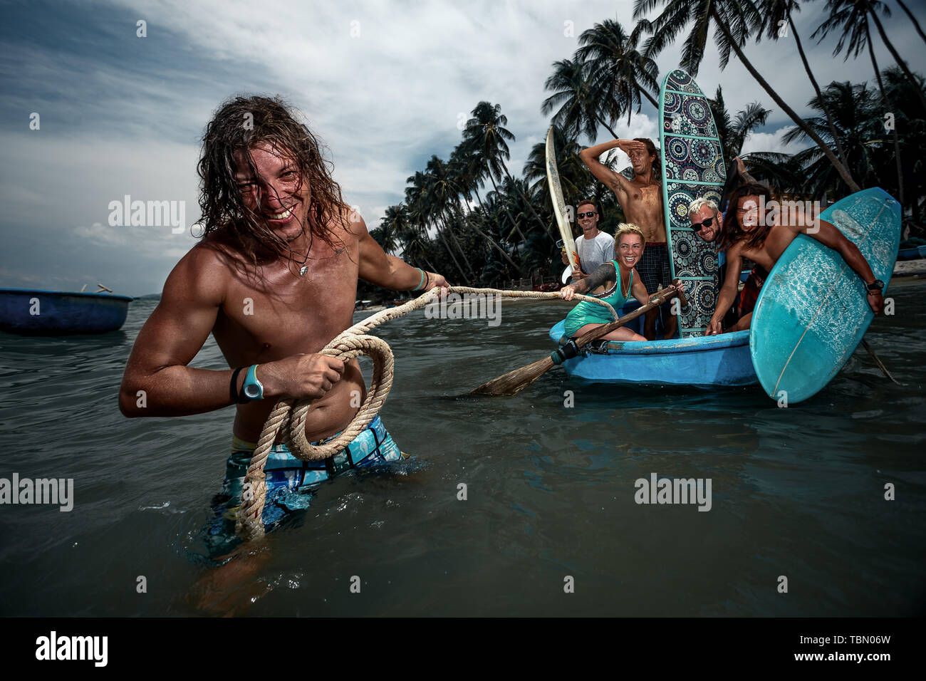 Group of surfers ride on vietnamese wooden boat to surf session on ...