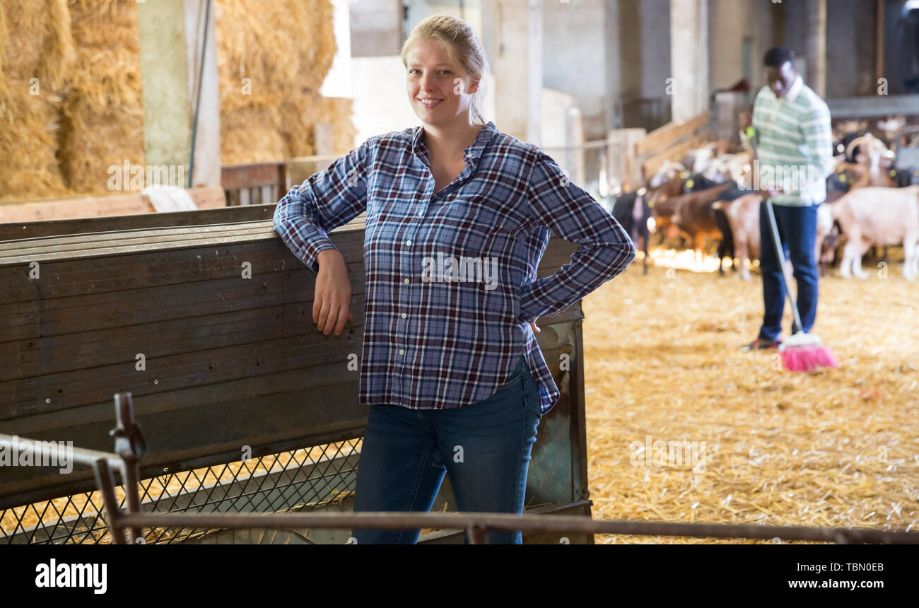 Portrait of confident woman professional goat breeder in stall on goat ...