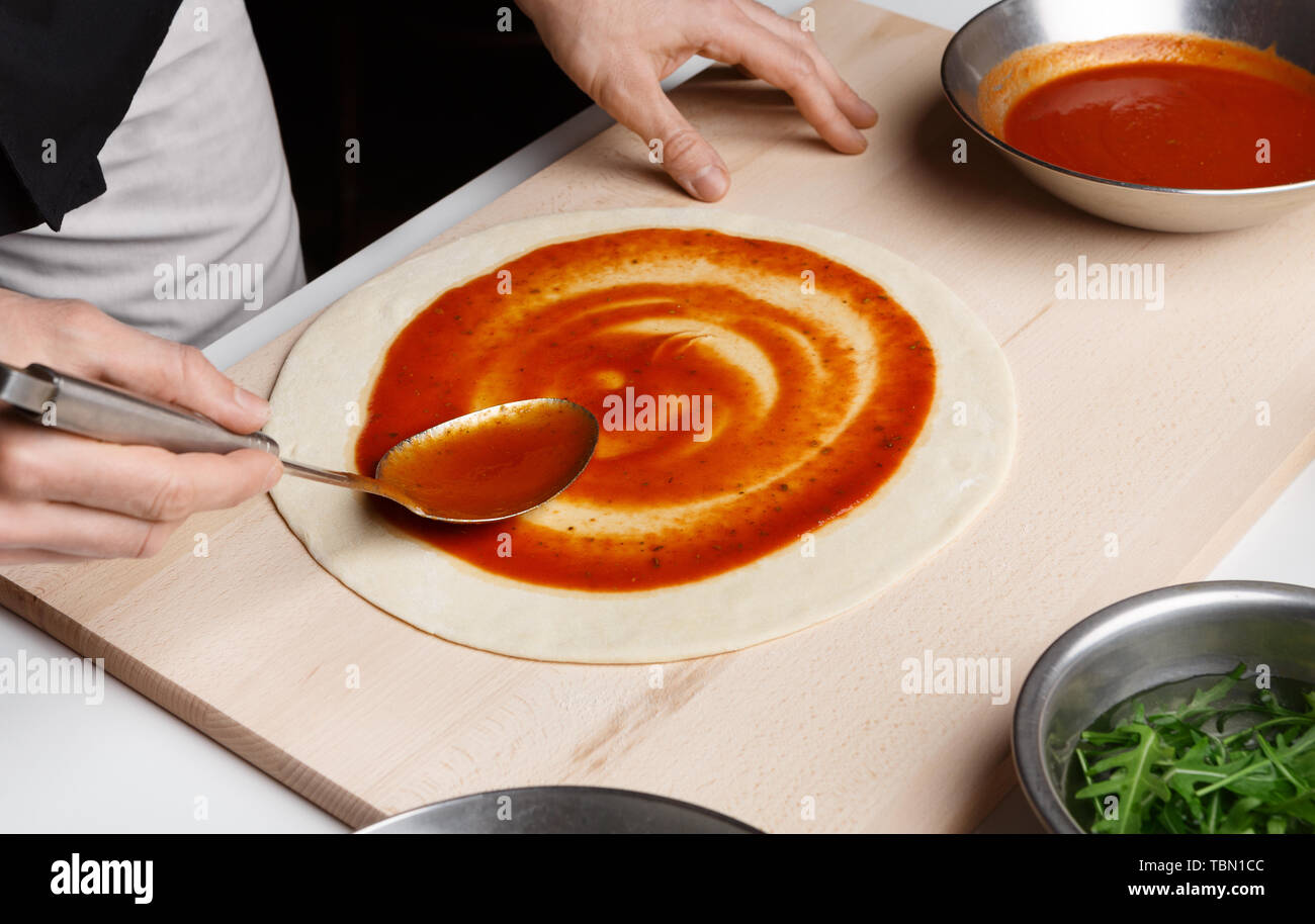 Italian Pizza Preparation. Chef Adding Sauce On Pizza Base Stock Photo ...