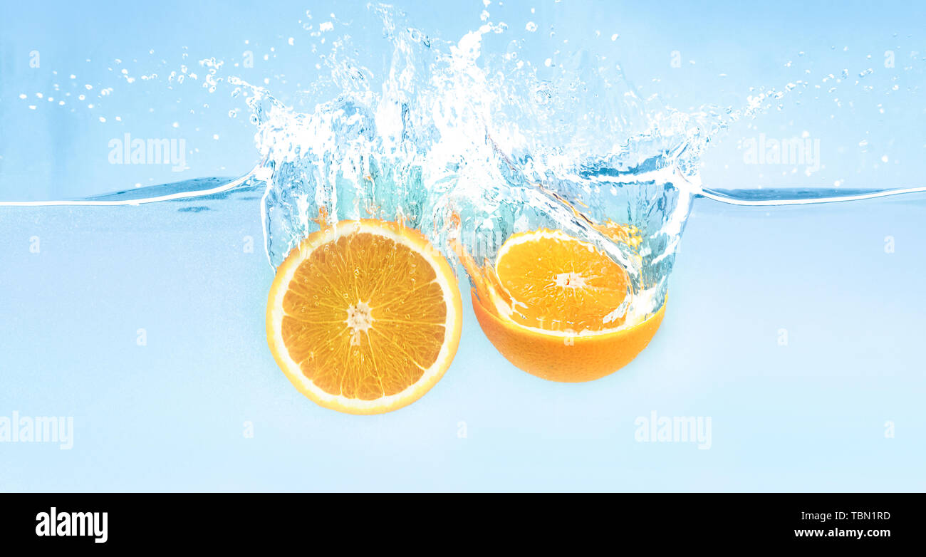 Splash of falling in water fresh orange halves Stock Photo - Alamy