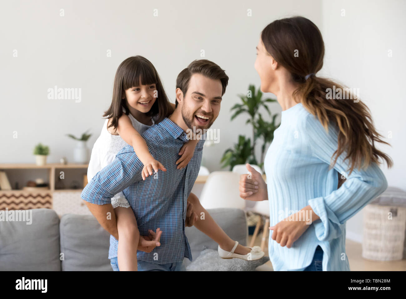 Playful parents have fun playing with preschooler daughter Stock Photo ...