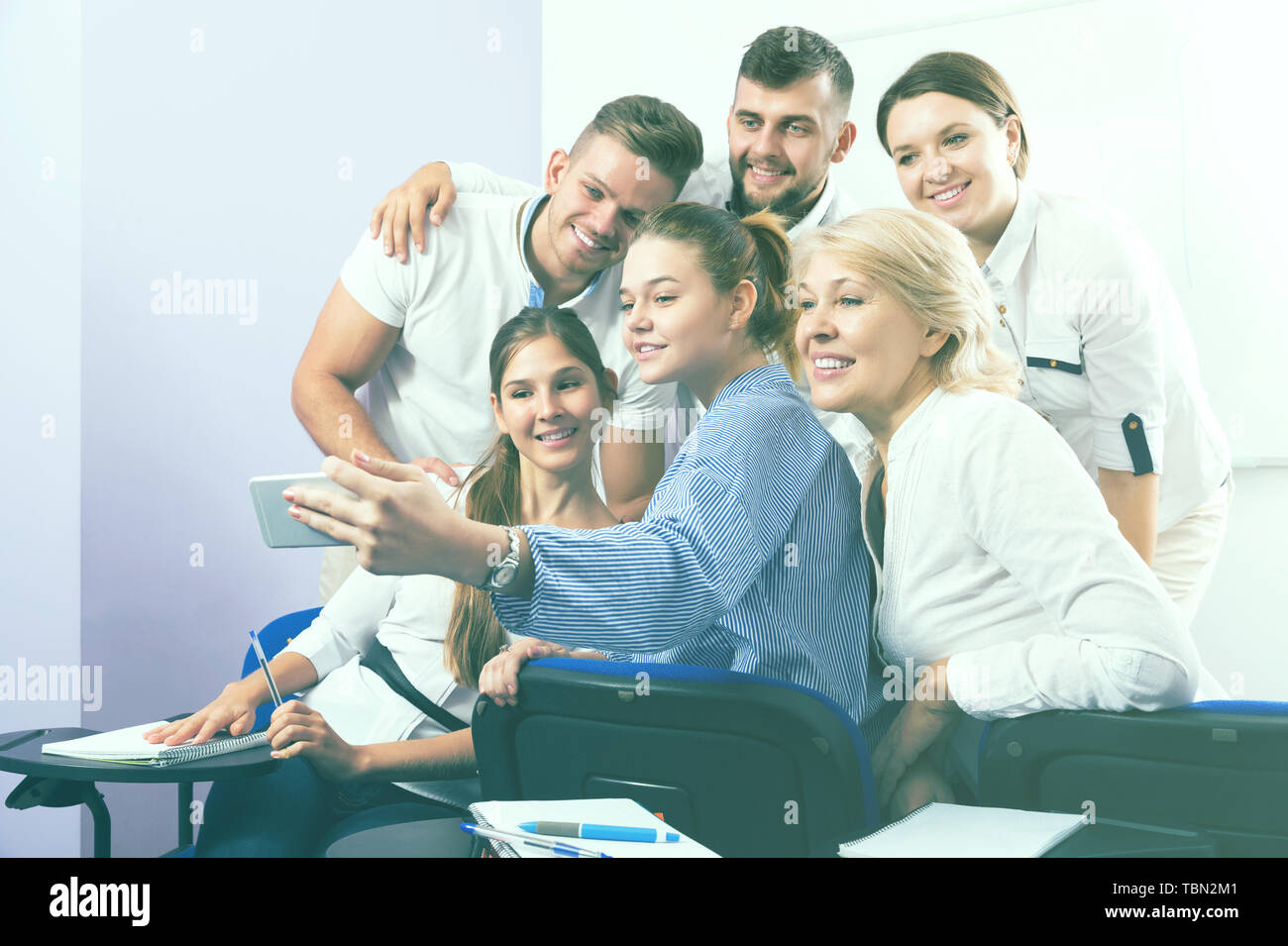 Group of happy students and female professor taking selfie in ...