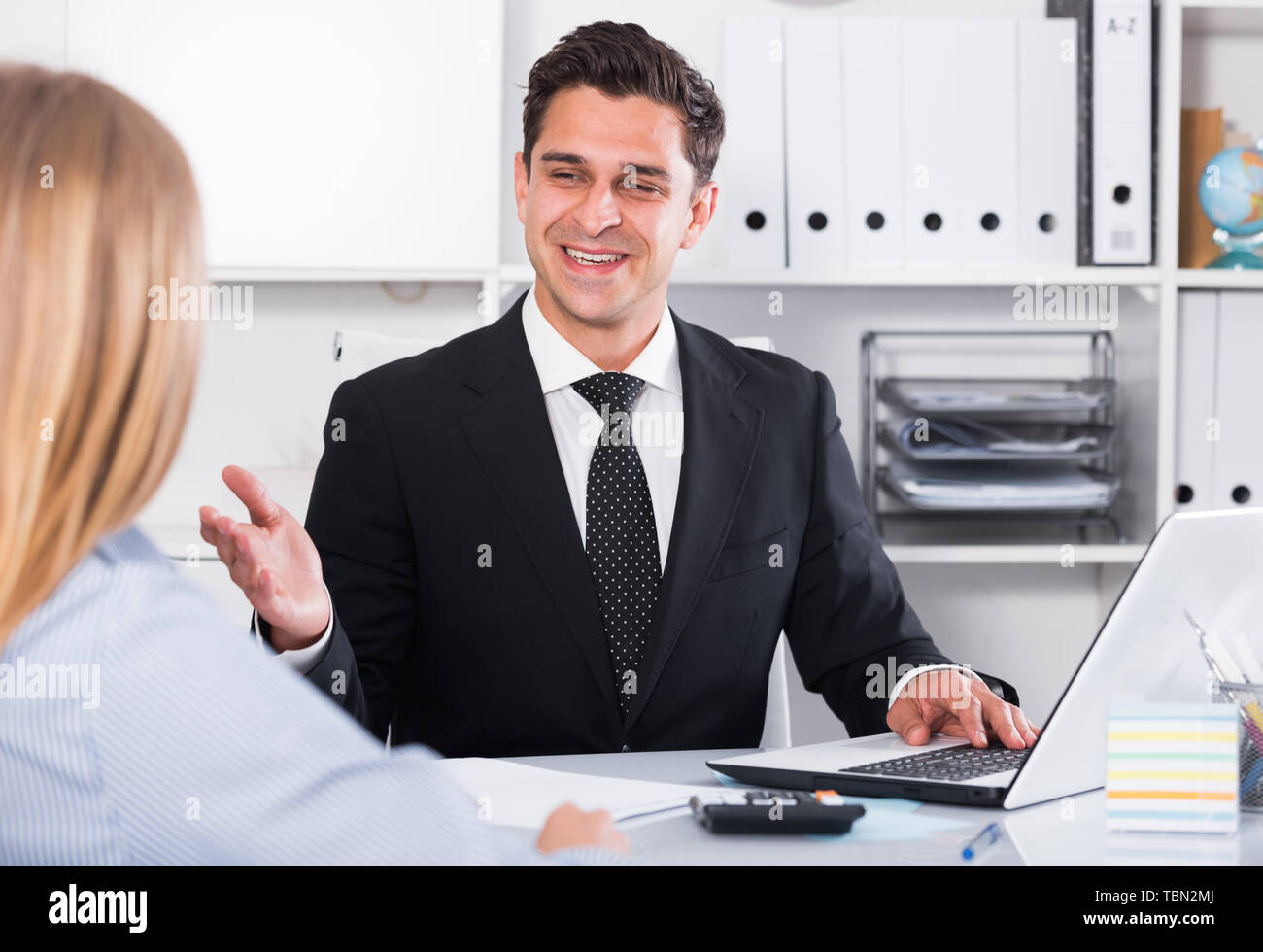 Smiling businessman welcoming female client at workplace in office ...