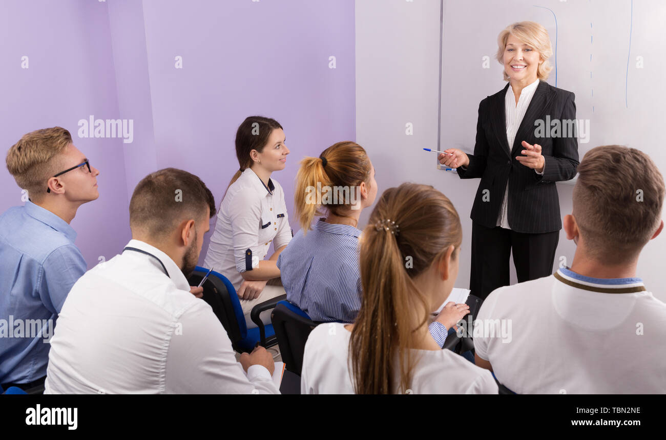 Elegant female teacher lecturing to students in auditorium Stock Photo ...