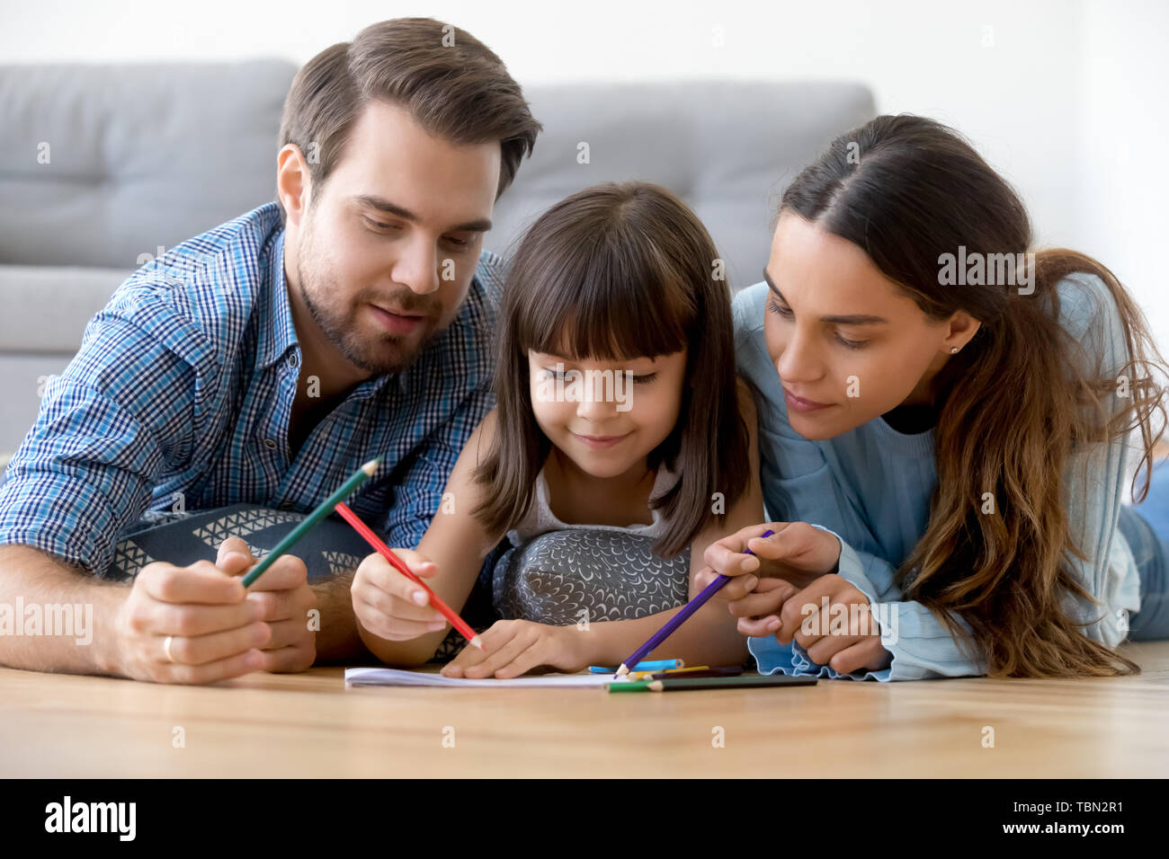Loving parents relax drawing together with small daughter Stock Photo ...
