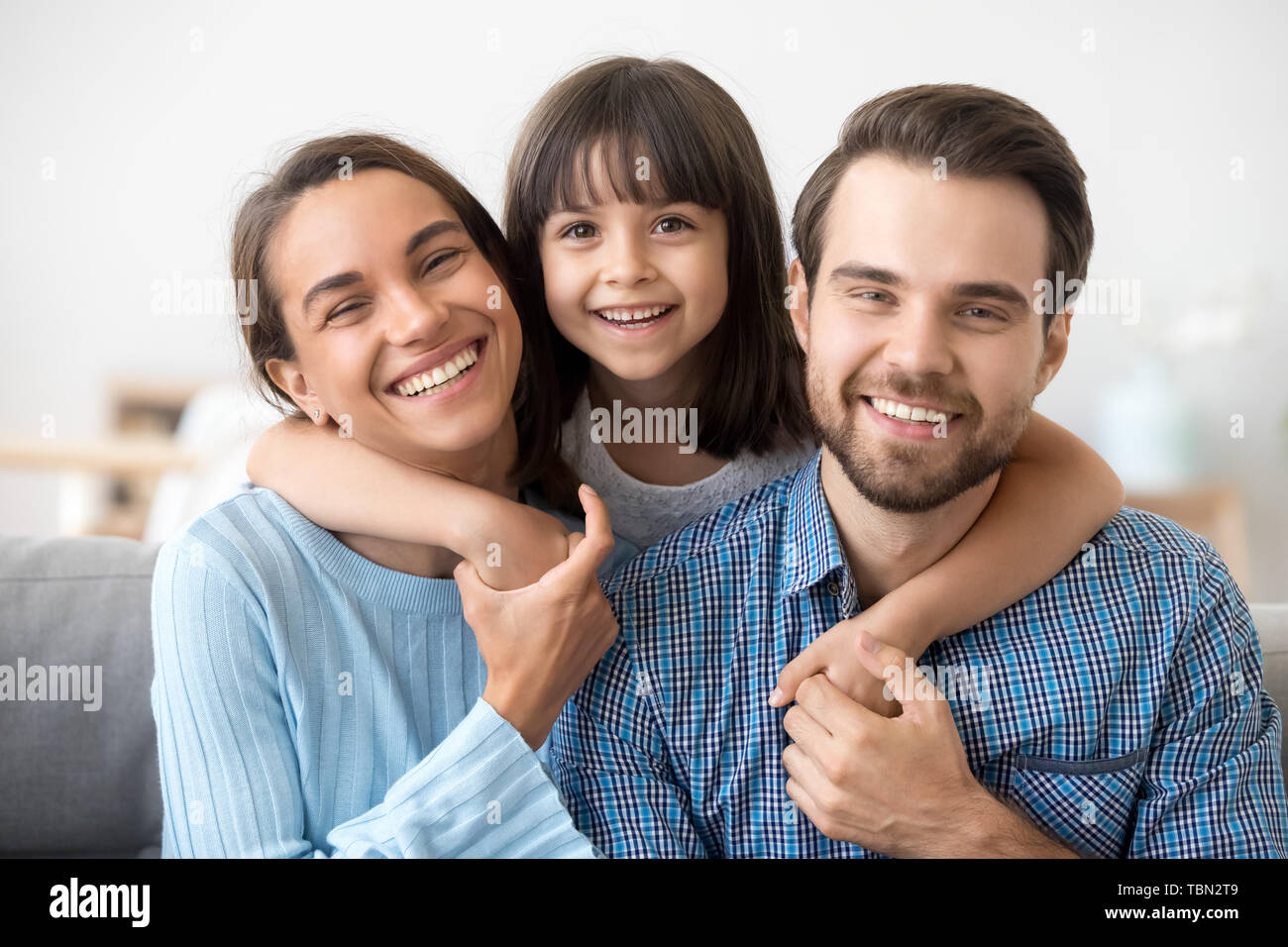 Family picture of funny preschooler hug smiling parents Stock Photo - Alamy