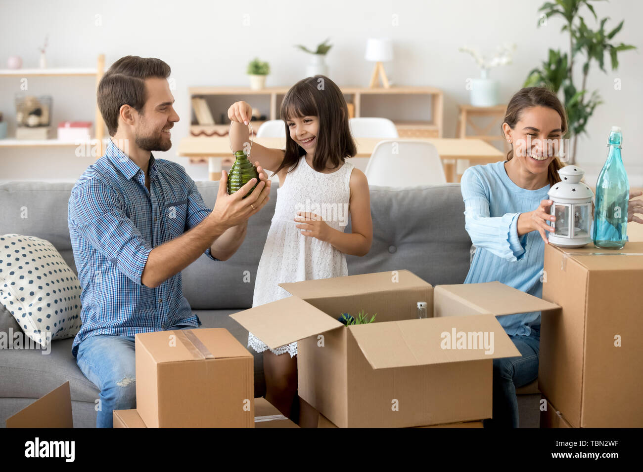 Happy young family unpack boxes moving to new home Stock Photo - Alamy