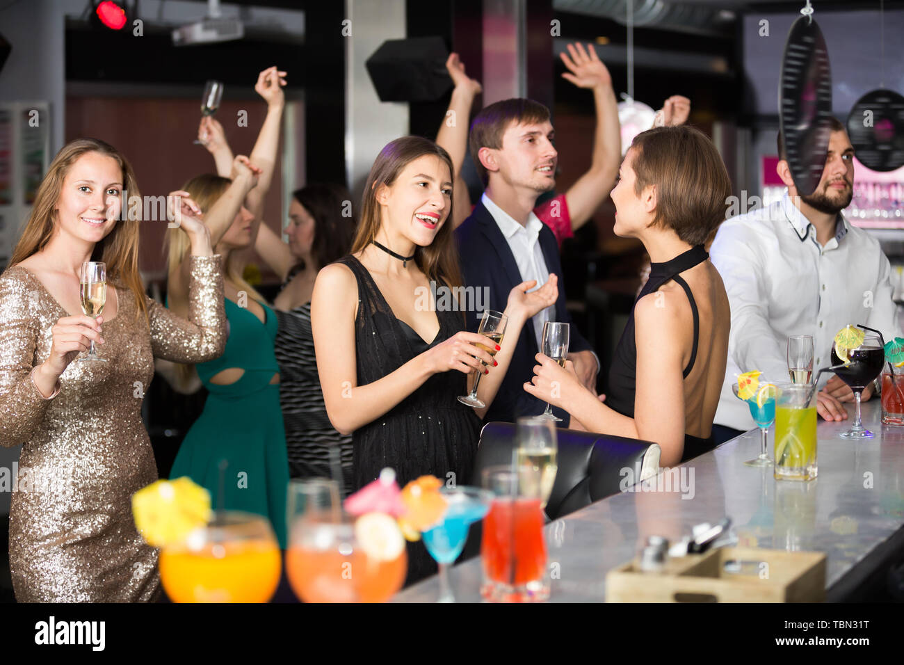 Positive colleagues dancing on corporate party with cocktails Stock ...