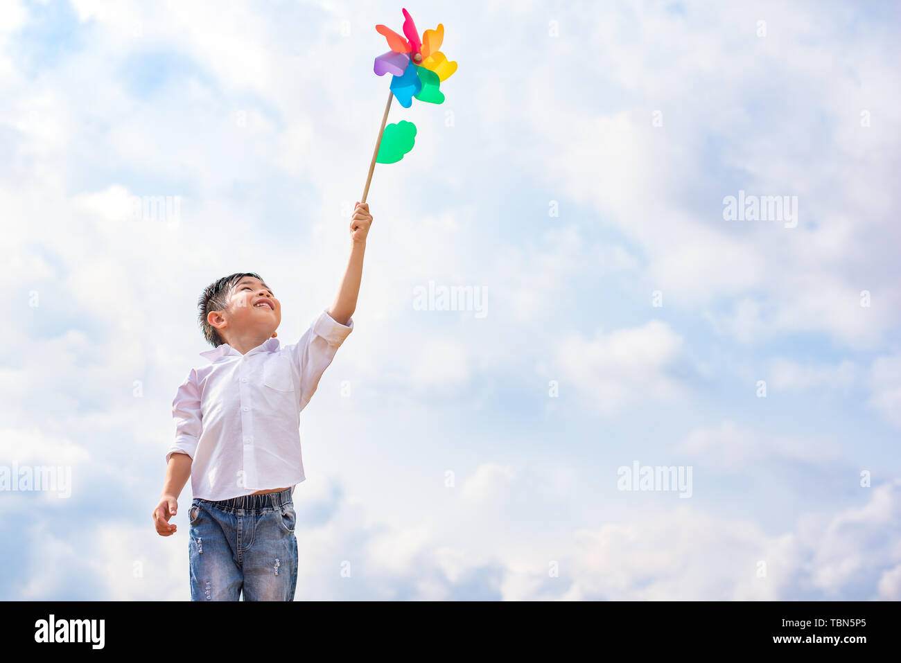 Boy holding colorful pinwheel in windy at outdoors. Children portrait ...