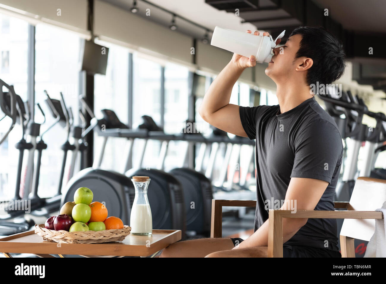 Handsome man drinking protein shake milk and many kind of fruits for ...