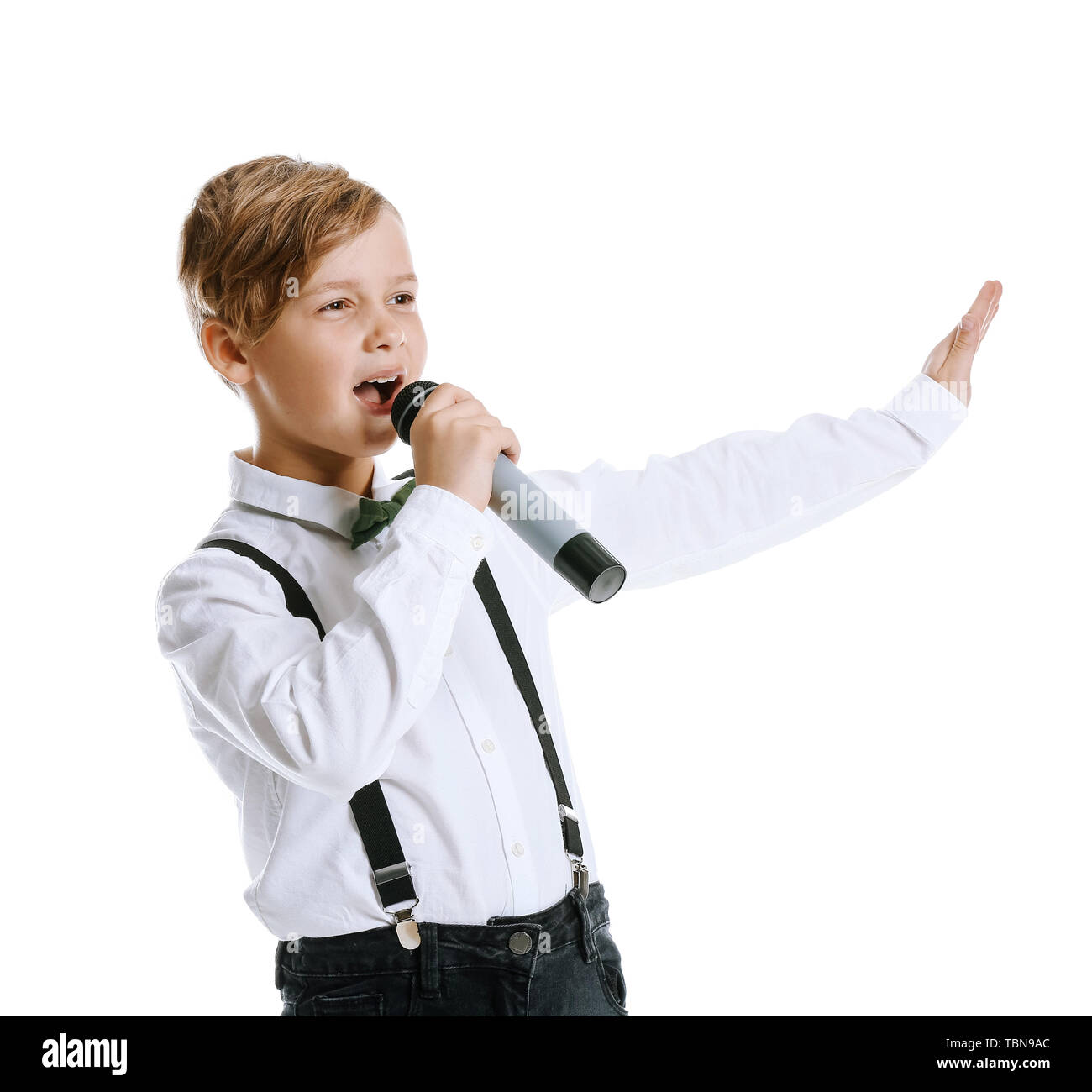 Cute little boy with microphone singing against white background Stock ...