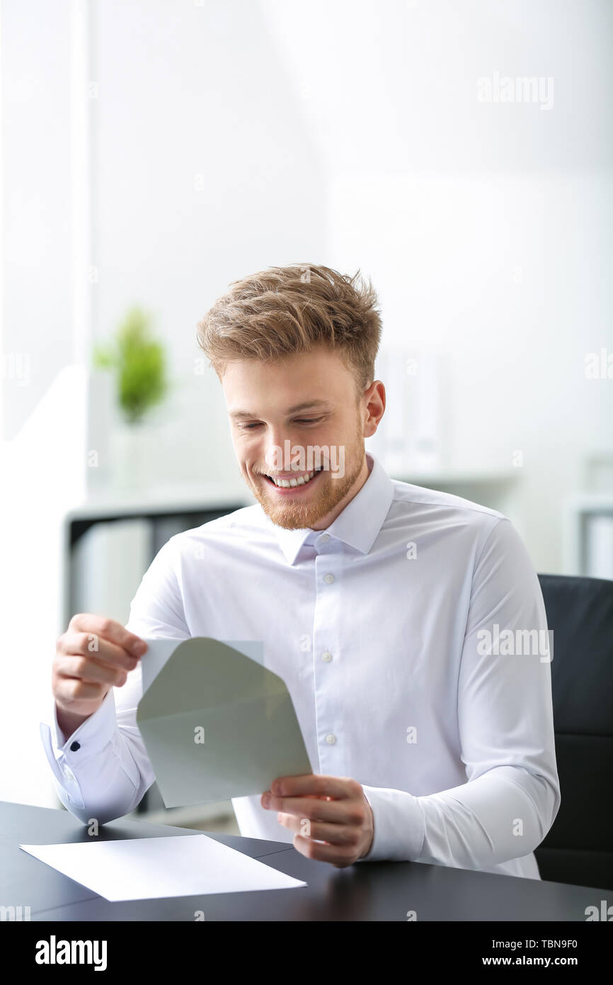 Young man receiving invitation in office Stock Photo - Alamy