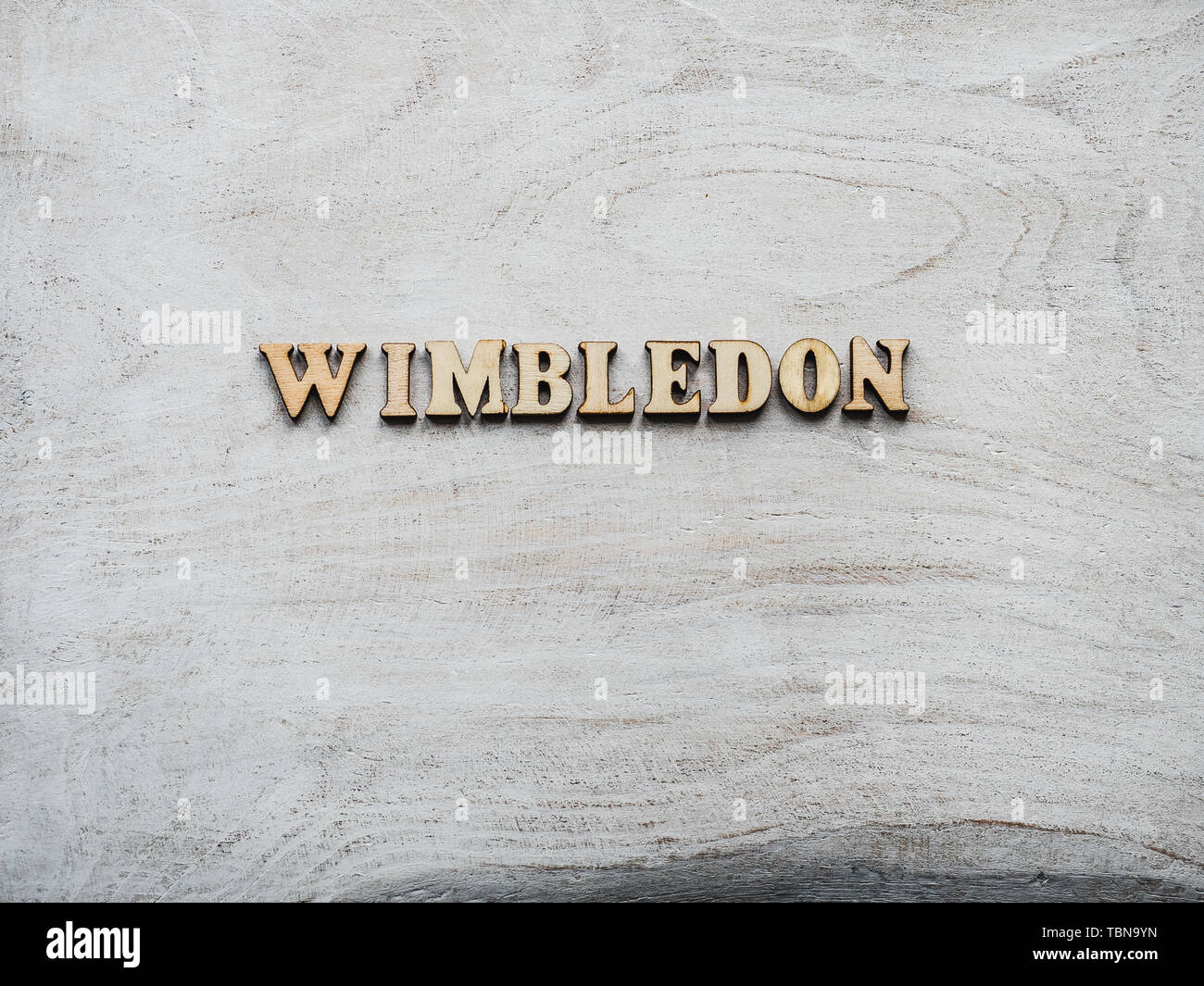 WIMBLEDON. Wooden, unpainted letters on a white table. Close-up, top ...