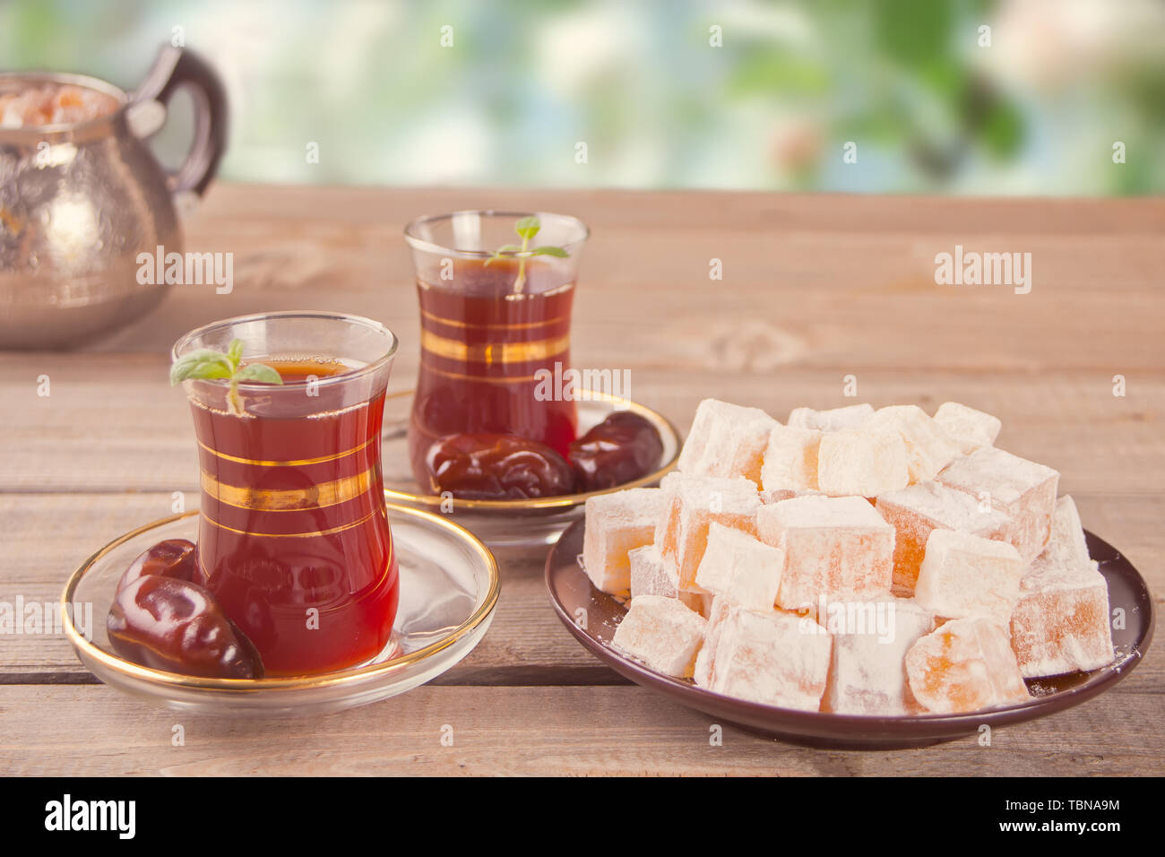 Turkish tea in traditional glass cups, date fruits and sweets on the ...