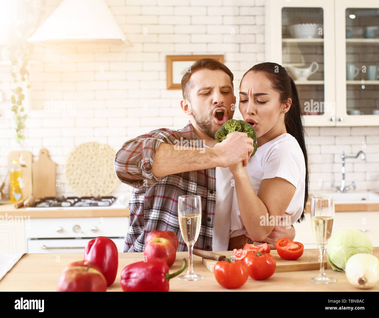 Young couple having fun while cooking together in kitchen Stock Photo ...