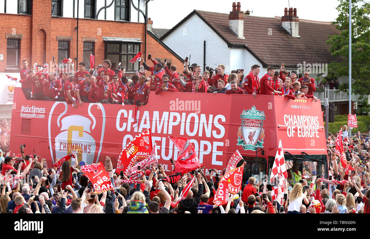 Liverpool players and staff on the bus pass the crowd of fans gathered ...