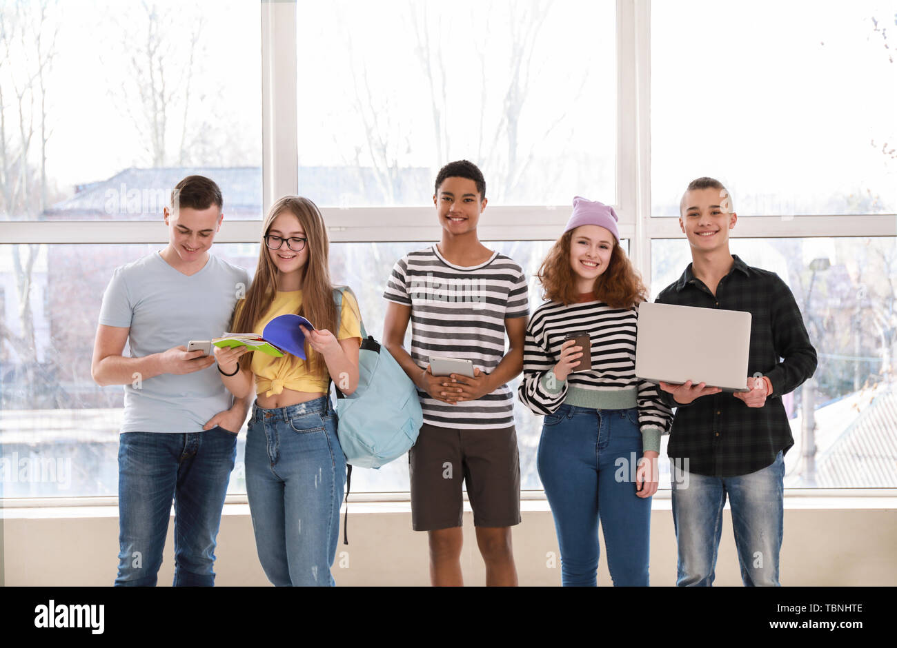 Teenagers with modern devices indoors Stock Photo - Alamy