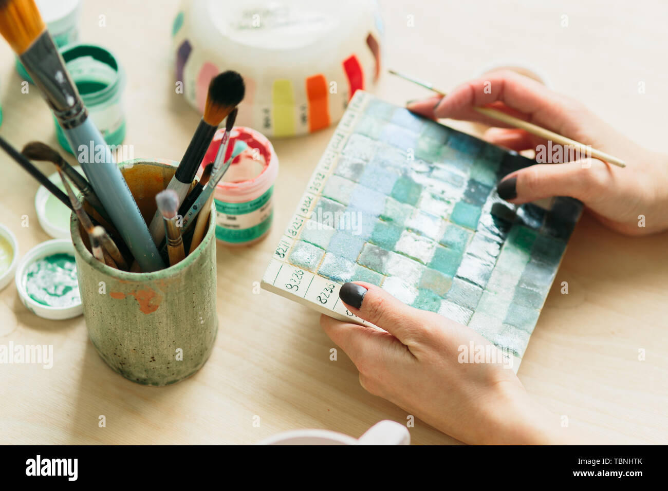 Potter holds the color palette glazes for coating ceramic products on ...