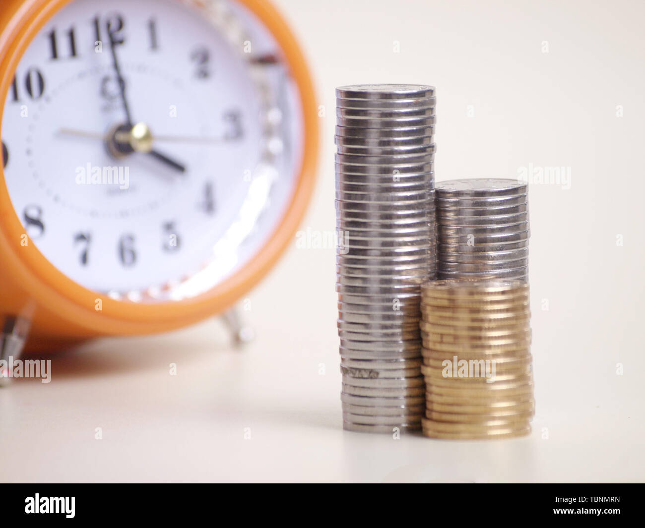 Coins and clocks Stock Photo - Alamy