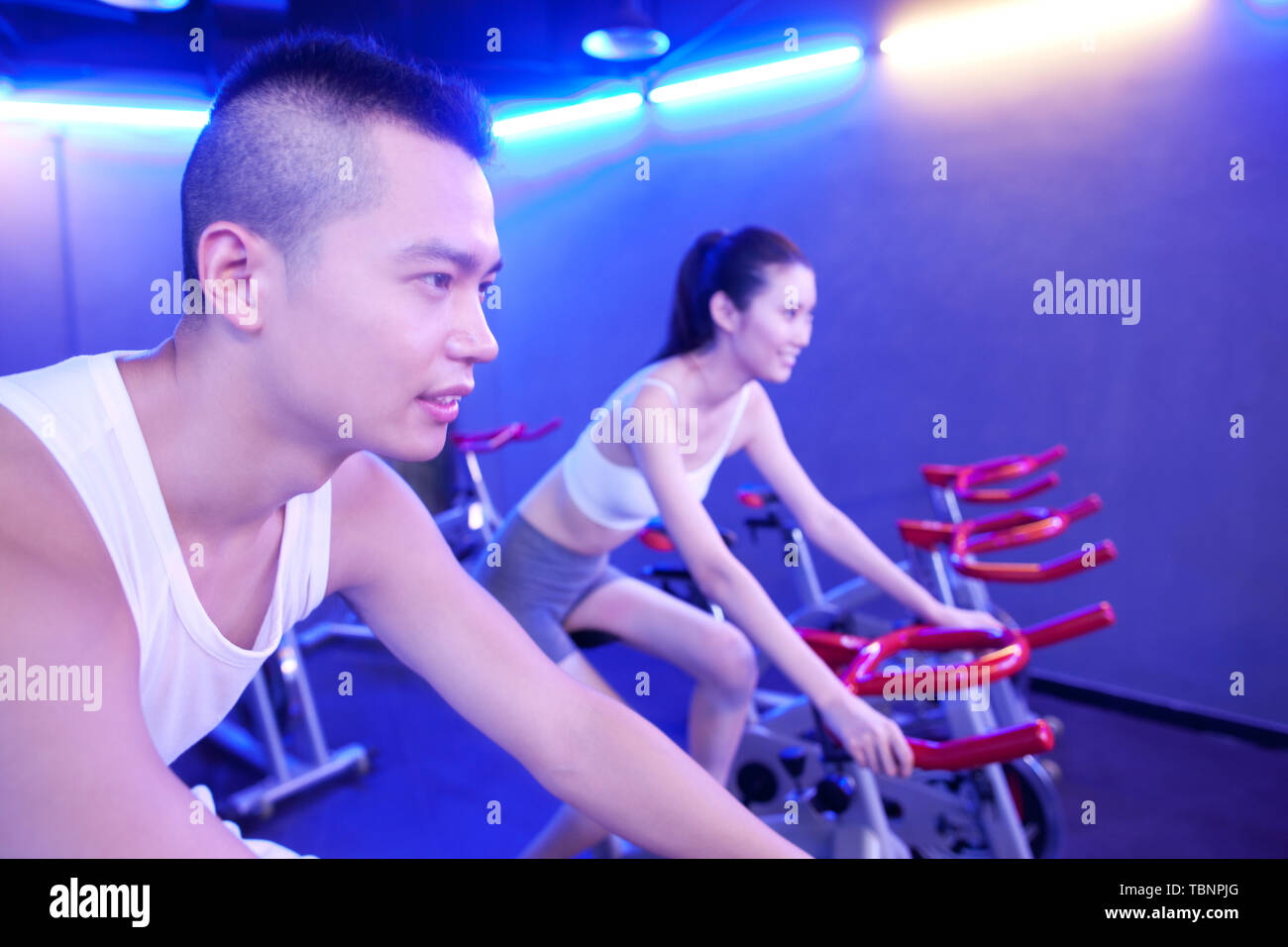 Riding a gym bike at the gym Stock Photo - Alamy
