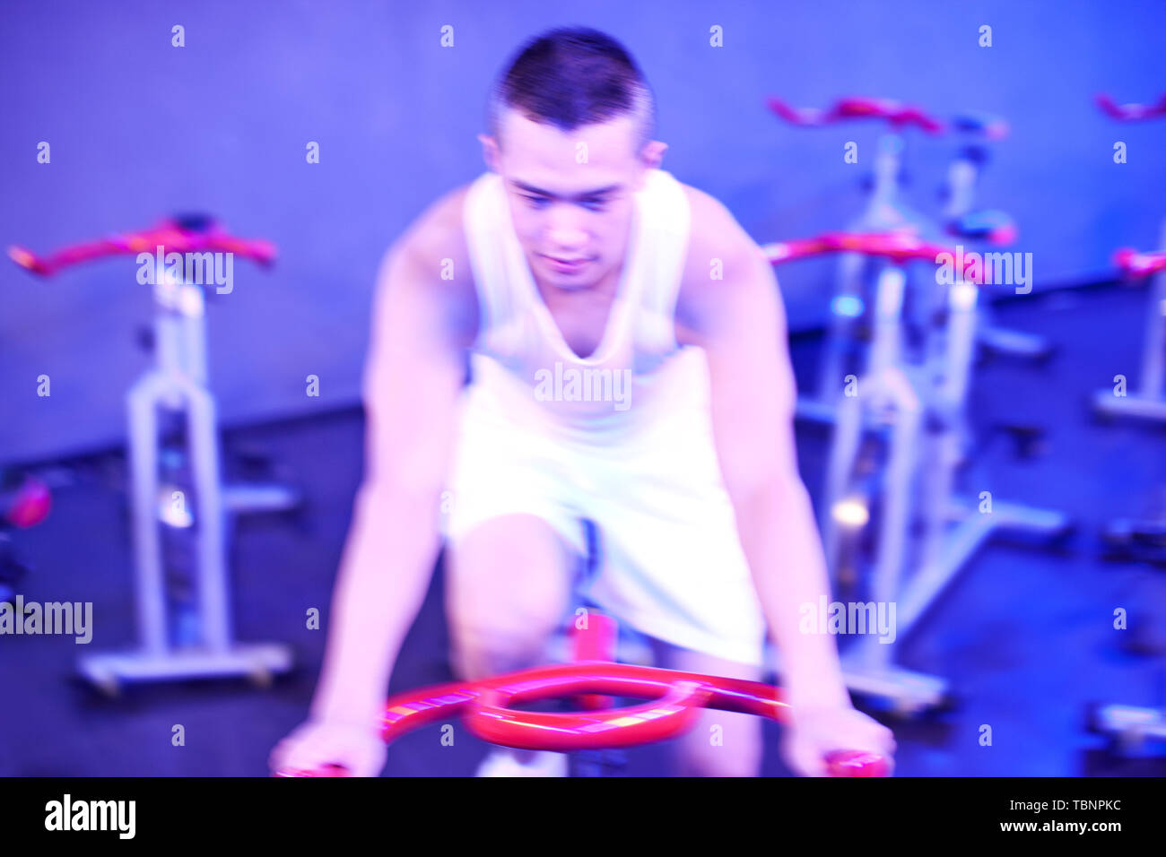 Riding a gym bike at the gym Stock Photo - Alamy